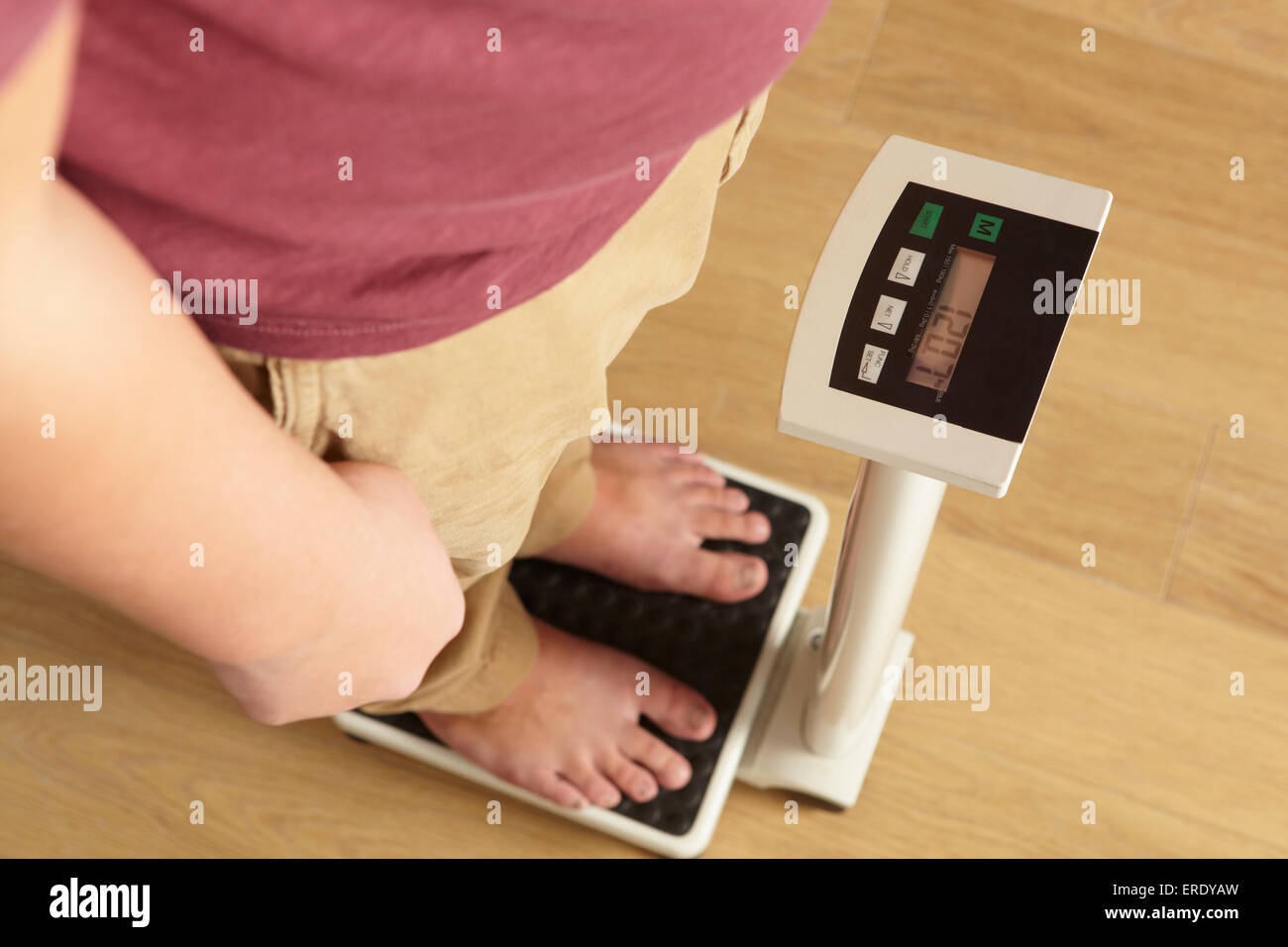 Man standing on digital scales cropped waist down Stock Photo - Alamy