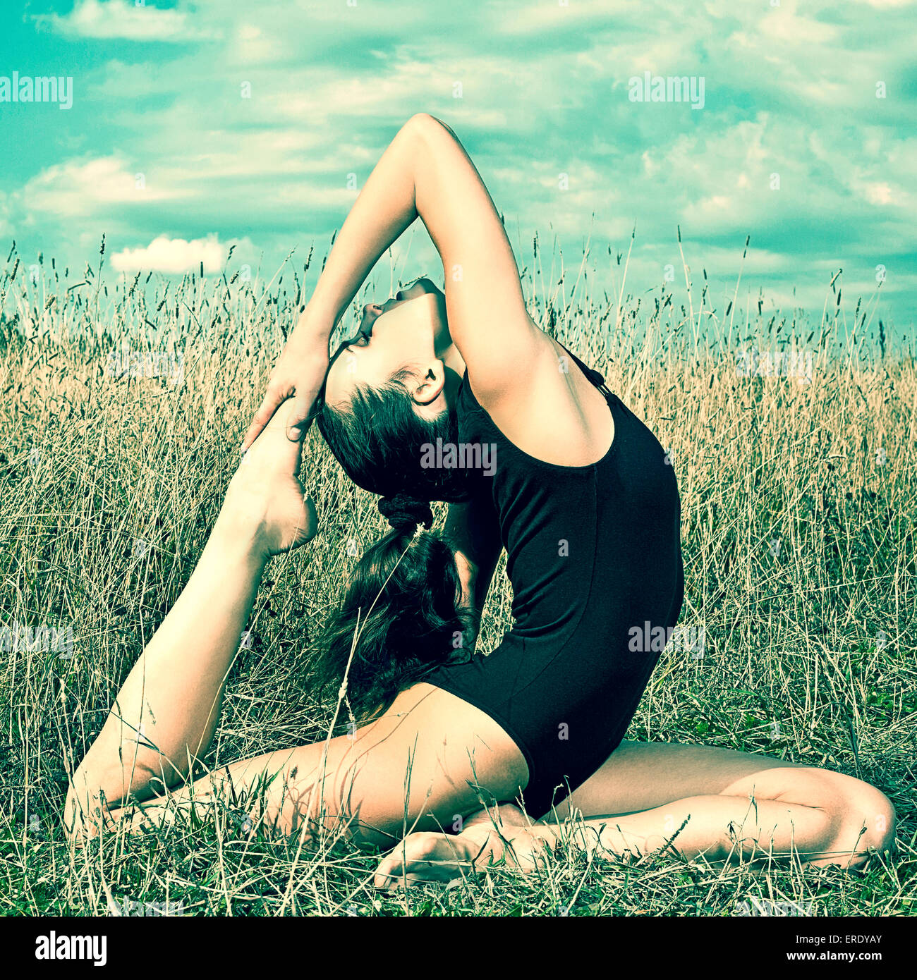 Caucasian woman doing backbend in tall grass Stock Photo - Alamy