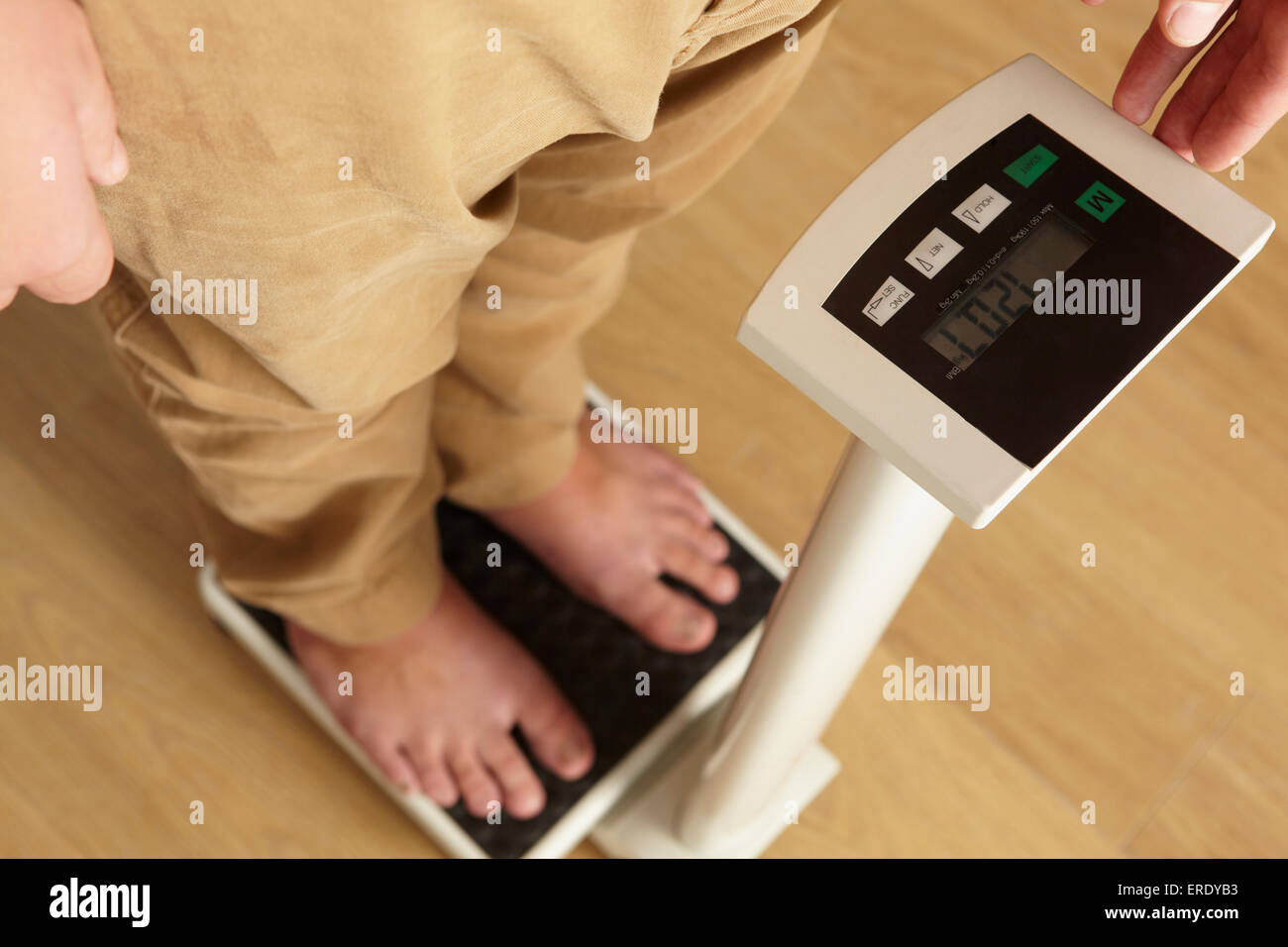 Man standing on digital scales cropped waist down Stock Photo - Alamy
