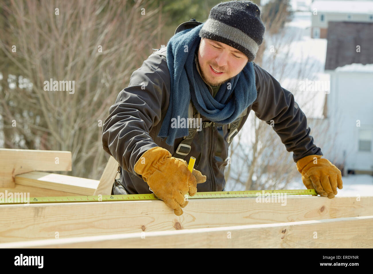 Caucasian carpenter measuring wood planks in winter Stock Photo - Alamy