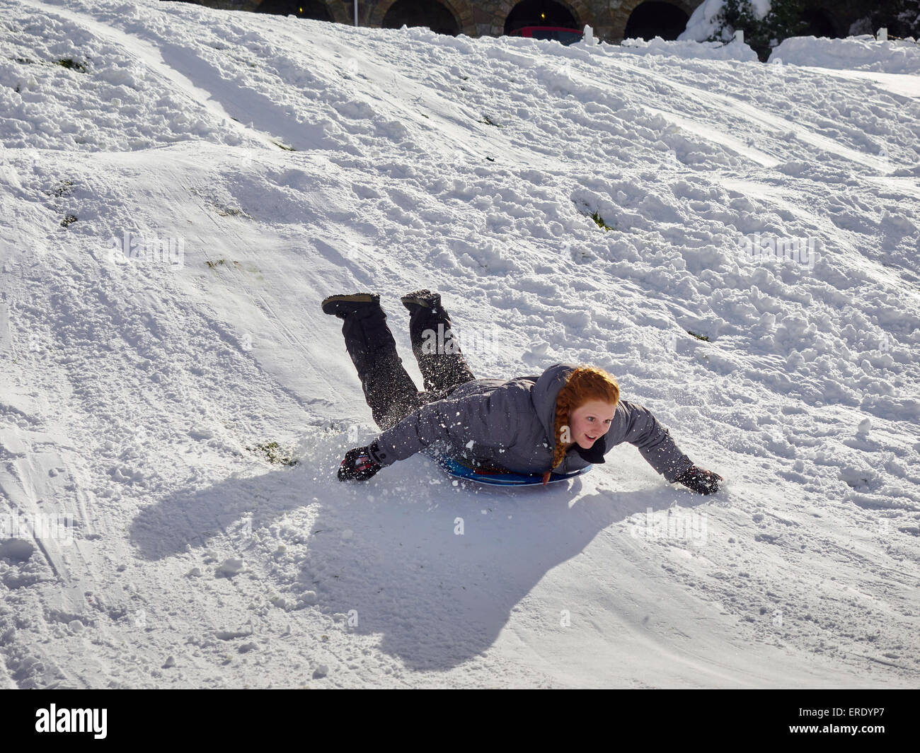 Caucasian teenage girl sledding on snowy hill Stock Photo - Alamy