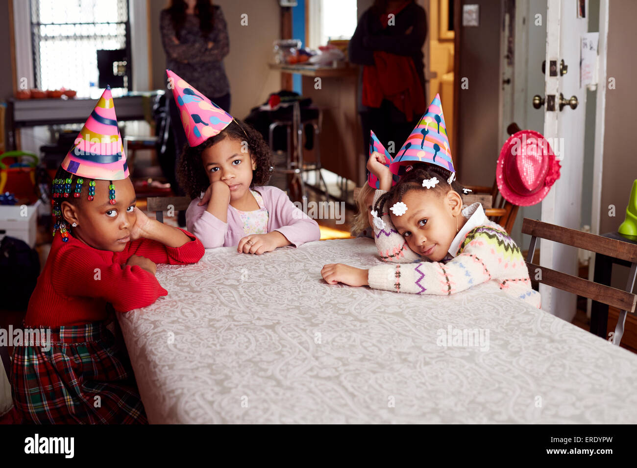 Bored children wearing party hats at table Stock Photo - Alamy