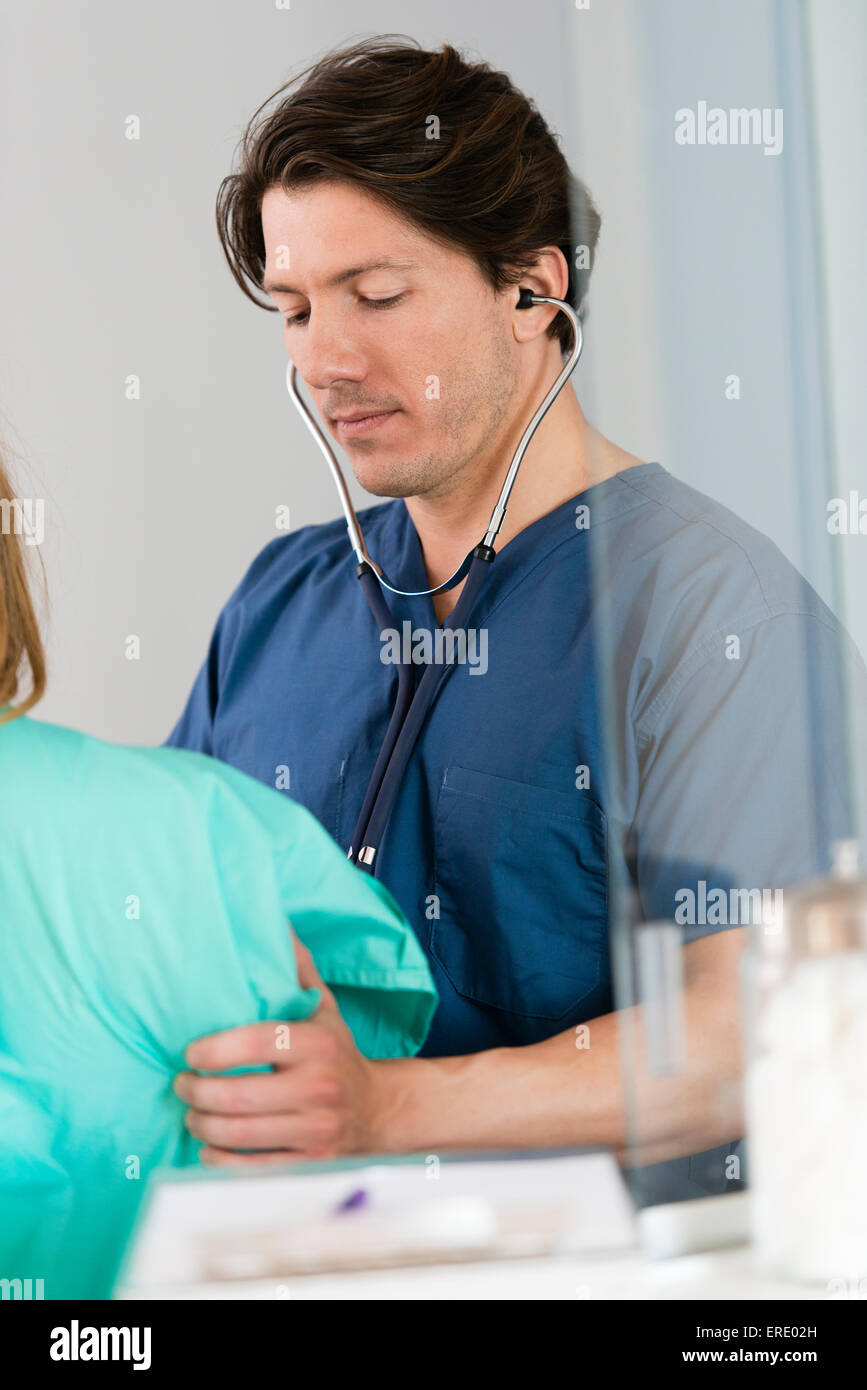 Doctor listening to heartbeat of patient Stock Photo - Alamy