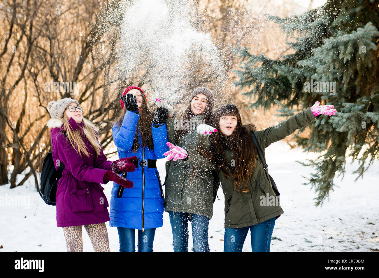 Caucasian girls throwing snow in field Stock Photo - Alamy