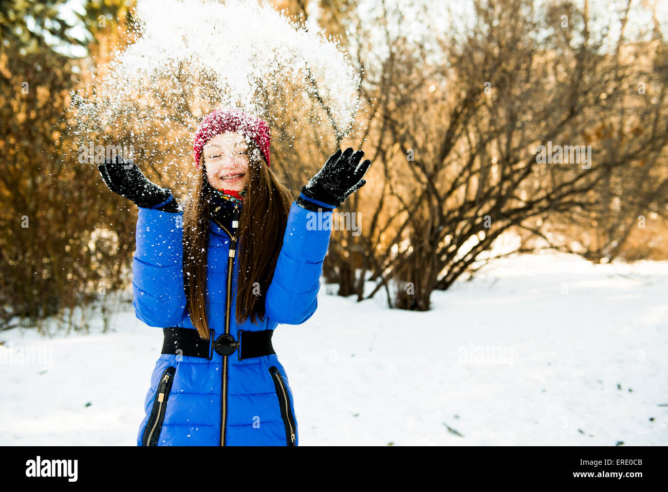 Caucasian girl throwing snow field Stock Photo - Alamy