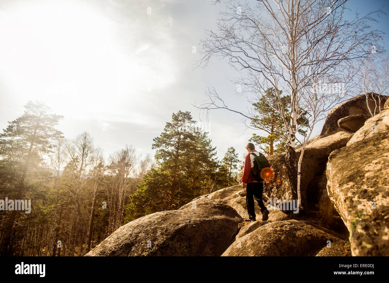 Caucasian man hiking on rock formations in remote forest Stock Photo ...