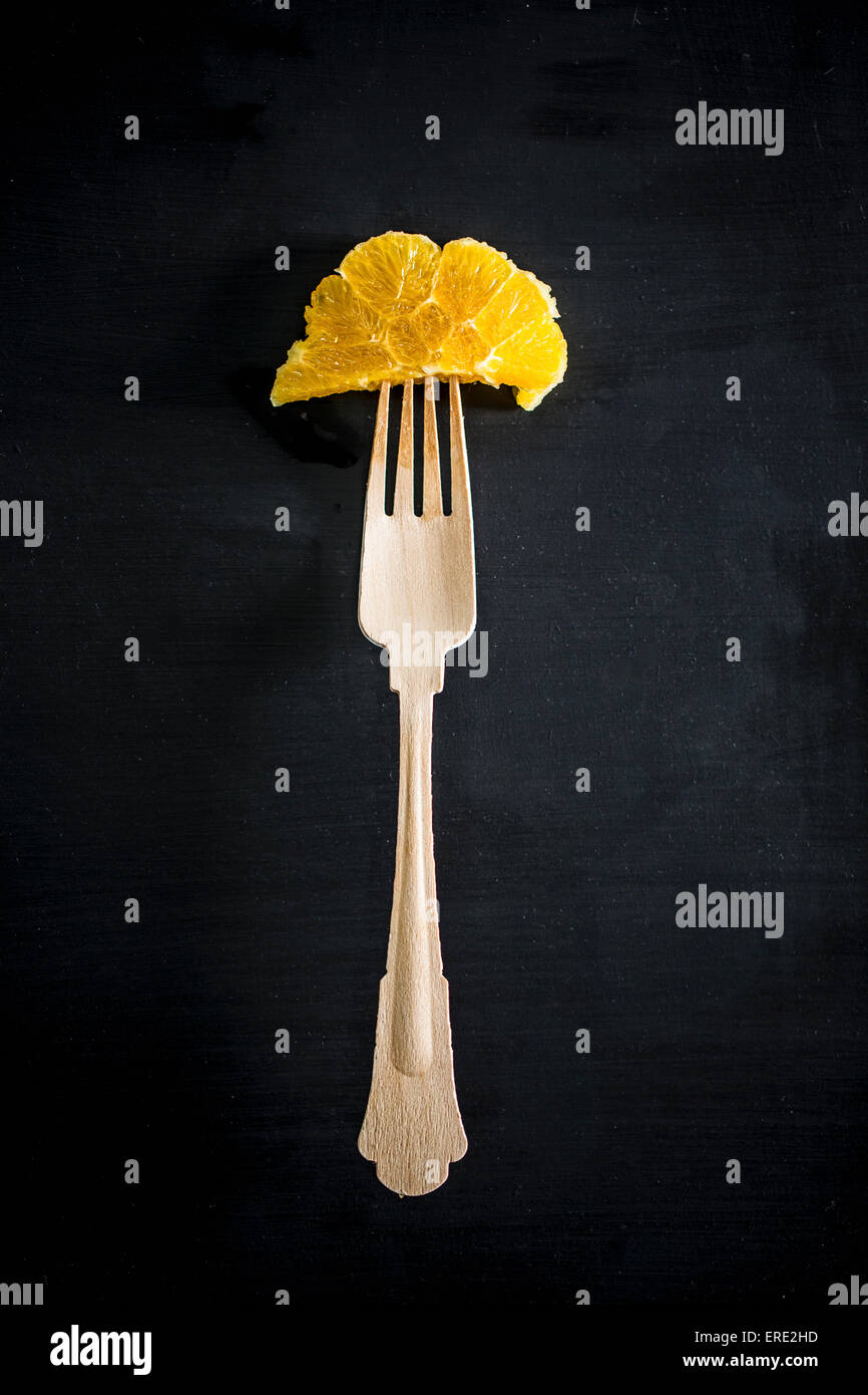 Fork with orange slice Stock Photo - Alamy