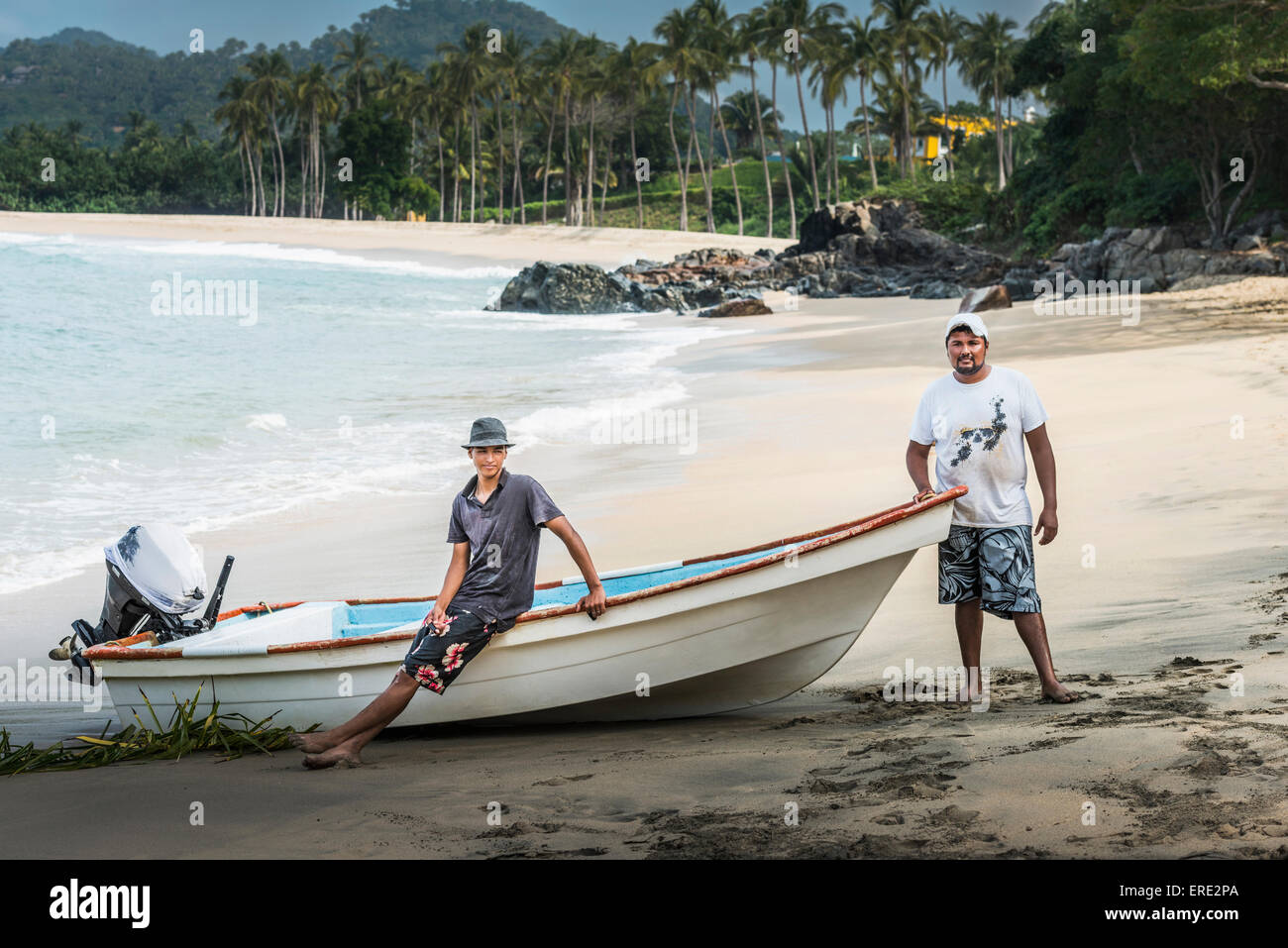 Friends standing near boat on beach Stock Photo - Alamy