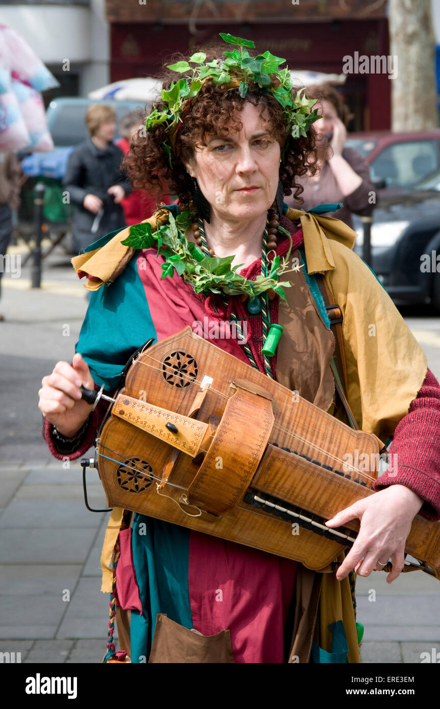 Woman playing a hurdy gurdy in fancy costume taking part in the St ...