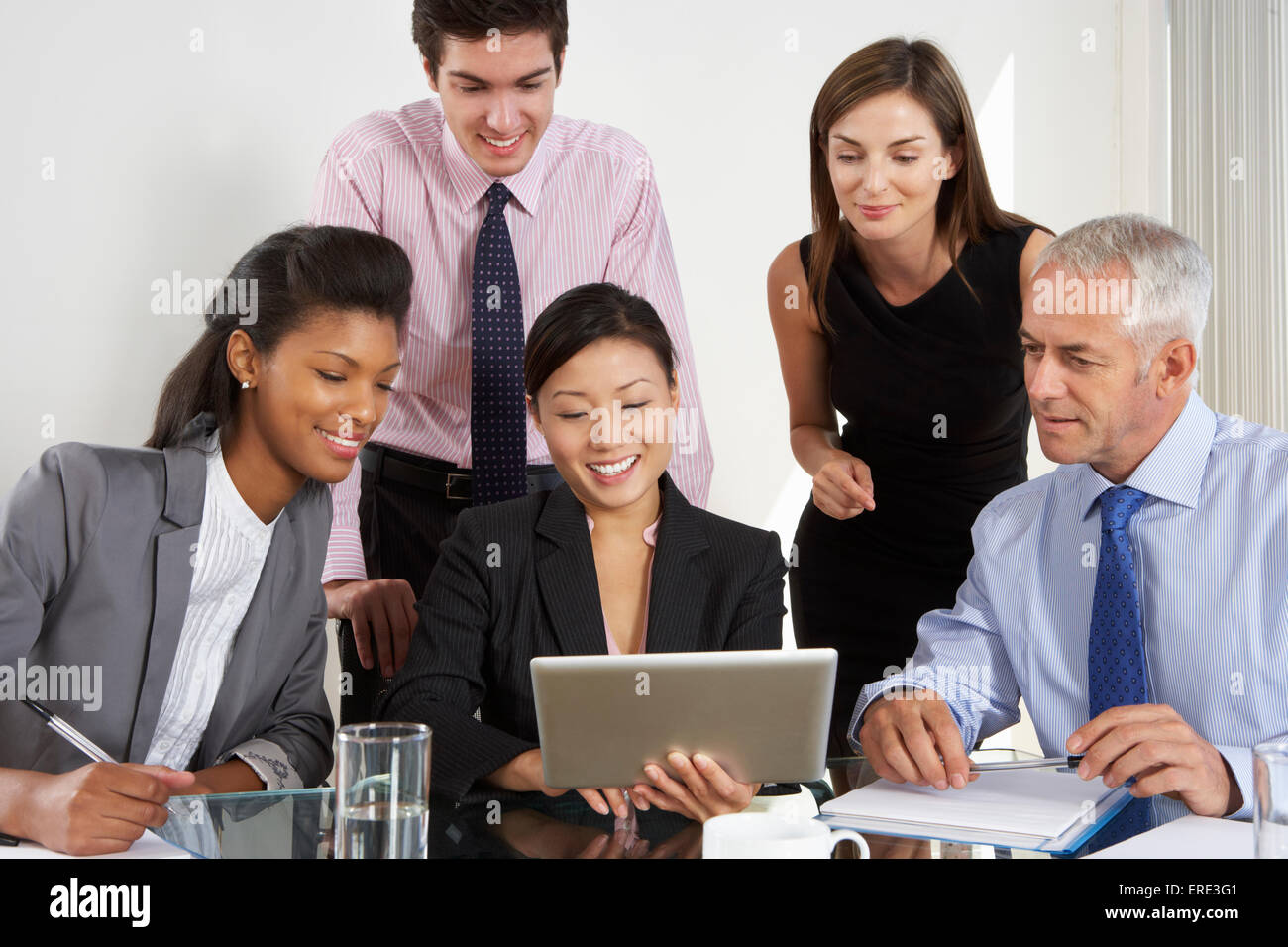 Group Of Business People Having Meeting Around Tablet Computer At Glass ...