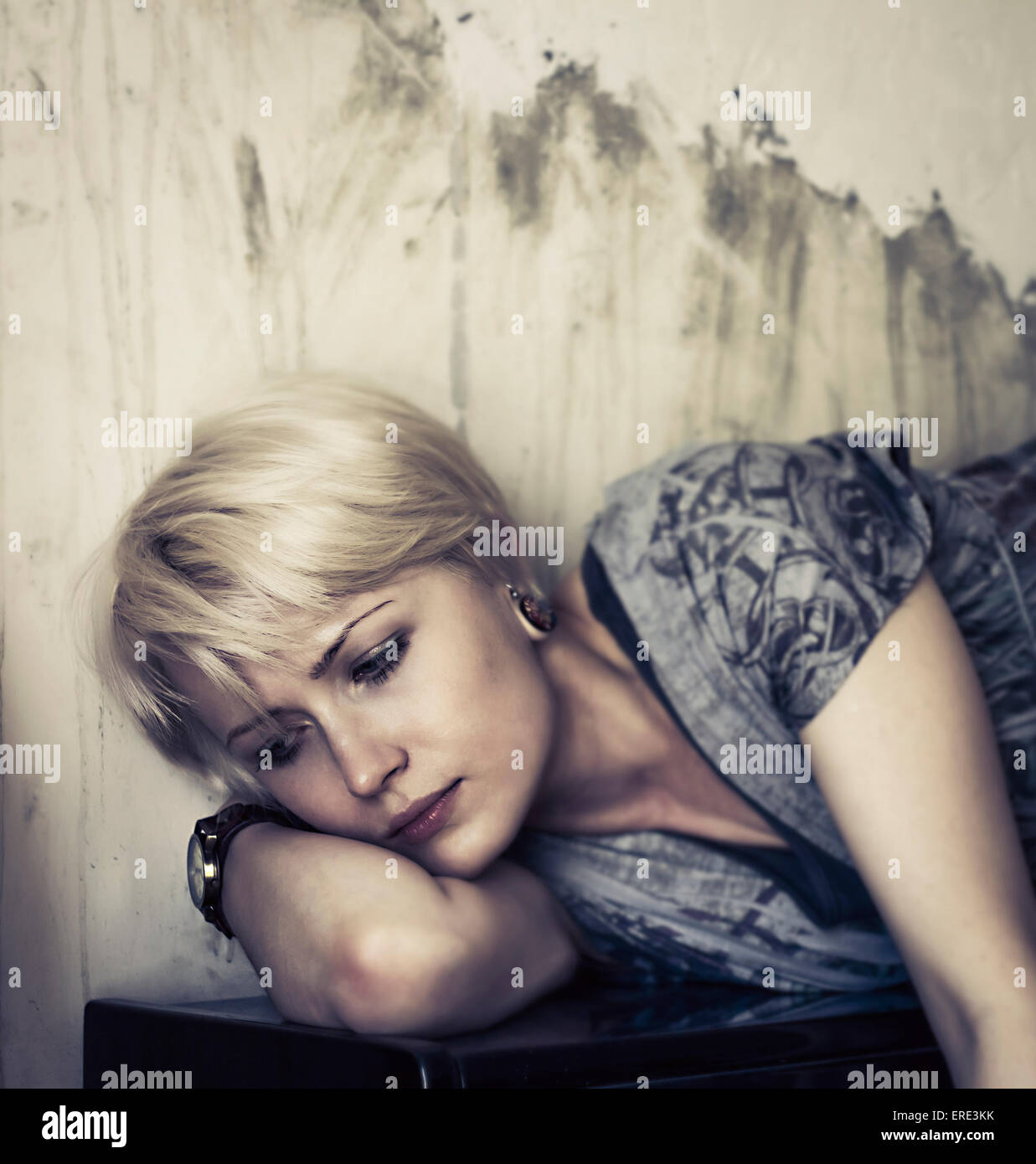 Pensive Caucasian woman laying on upright piano Stock Photo - Alamy