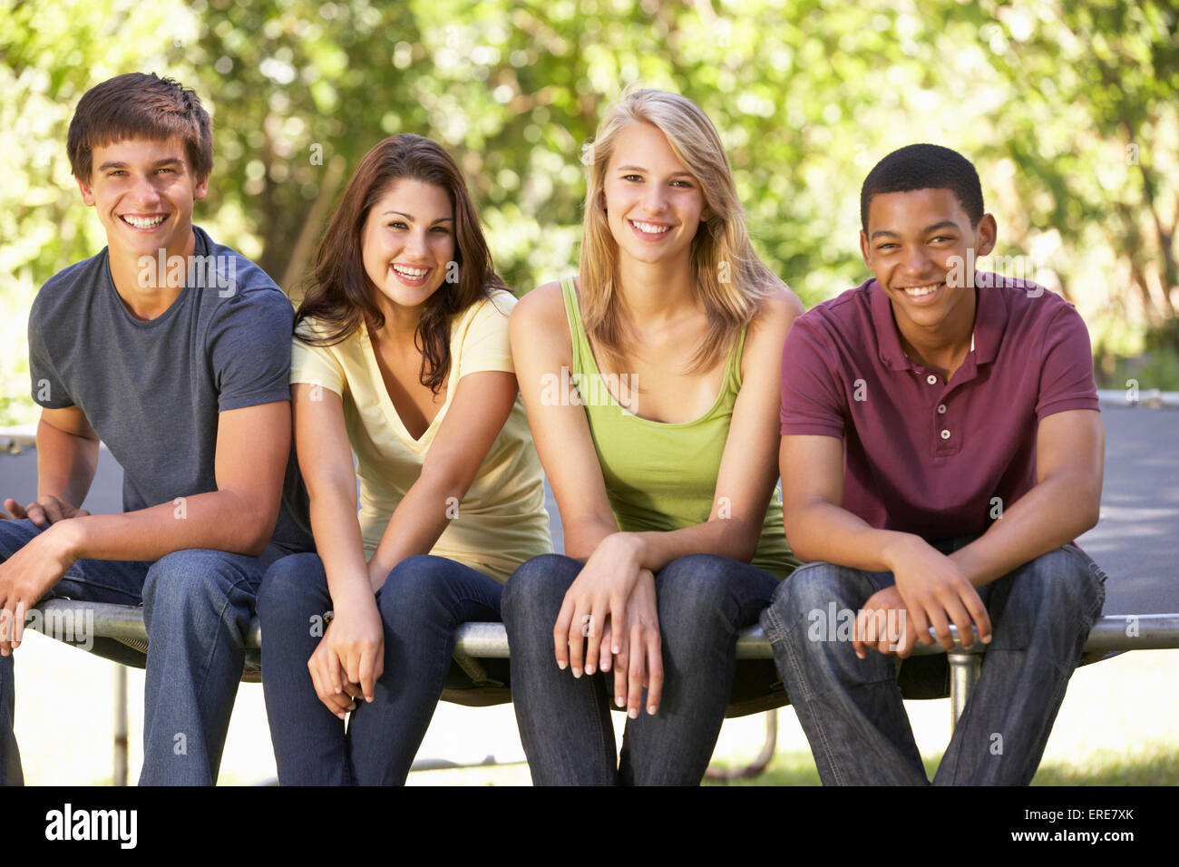 Four Teenage Friends Sitting On Trampoline In Garden Stock Photo - Alamy