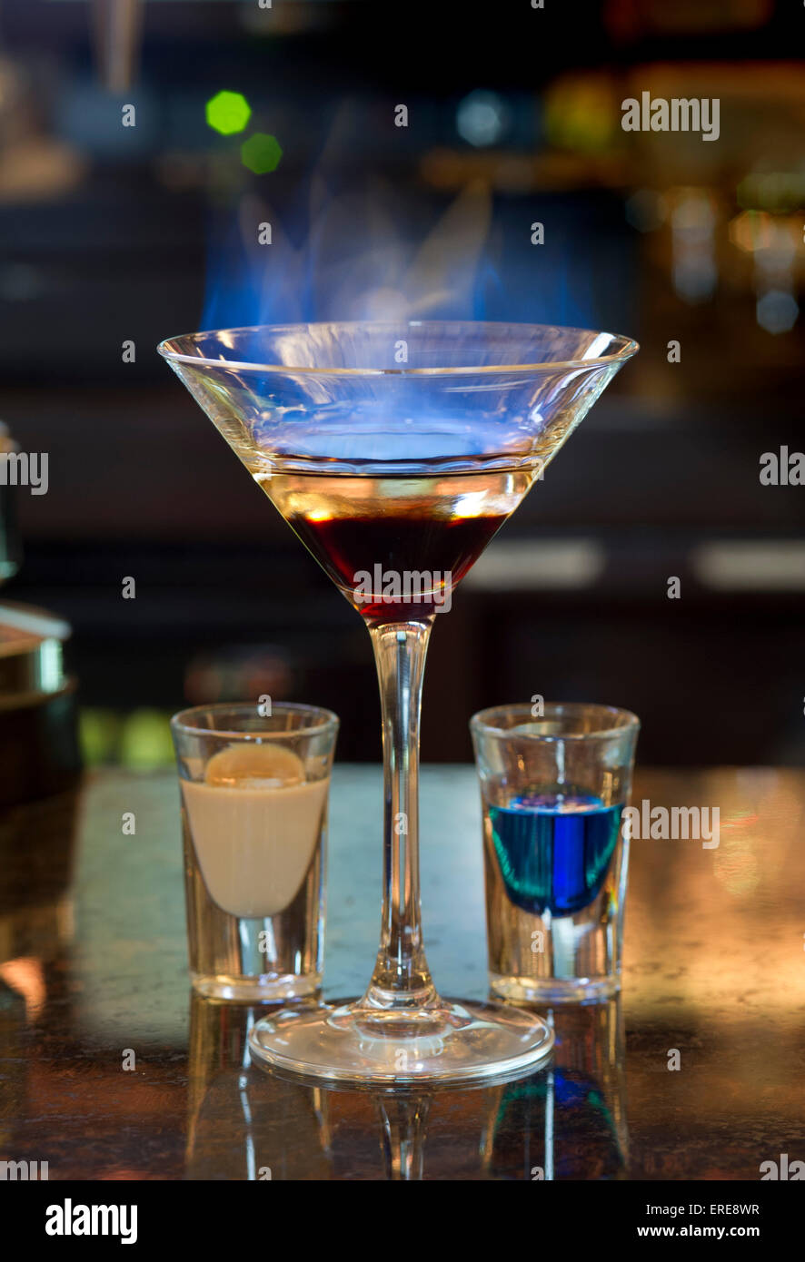 A flaming cocktail on a bar top.a UK drink drinks drinking alcohol ...