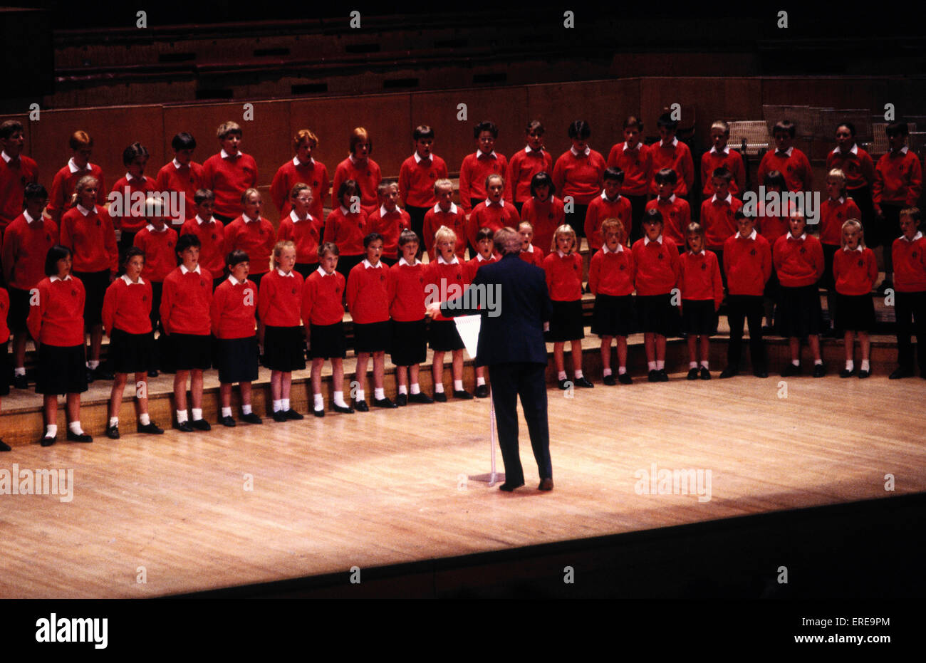 Choir of school girls singing wearing red uniform sweaters, white ...