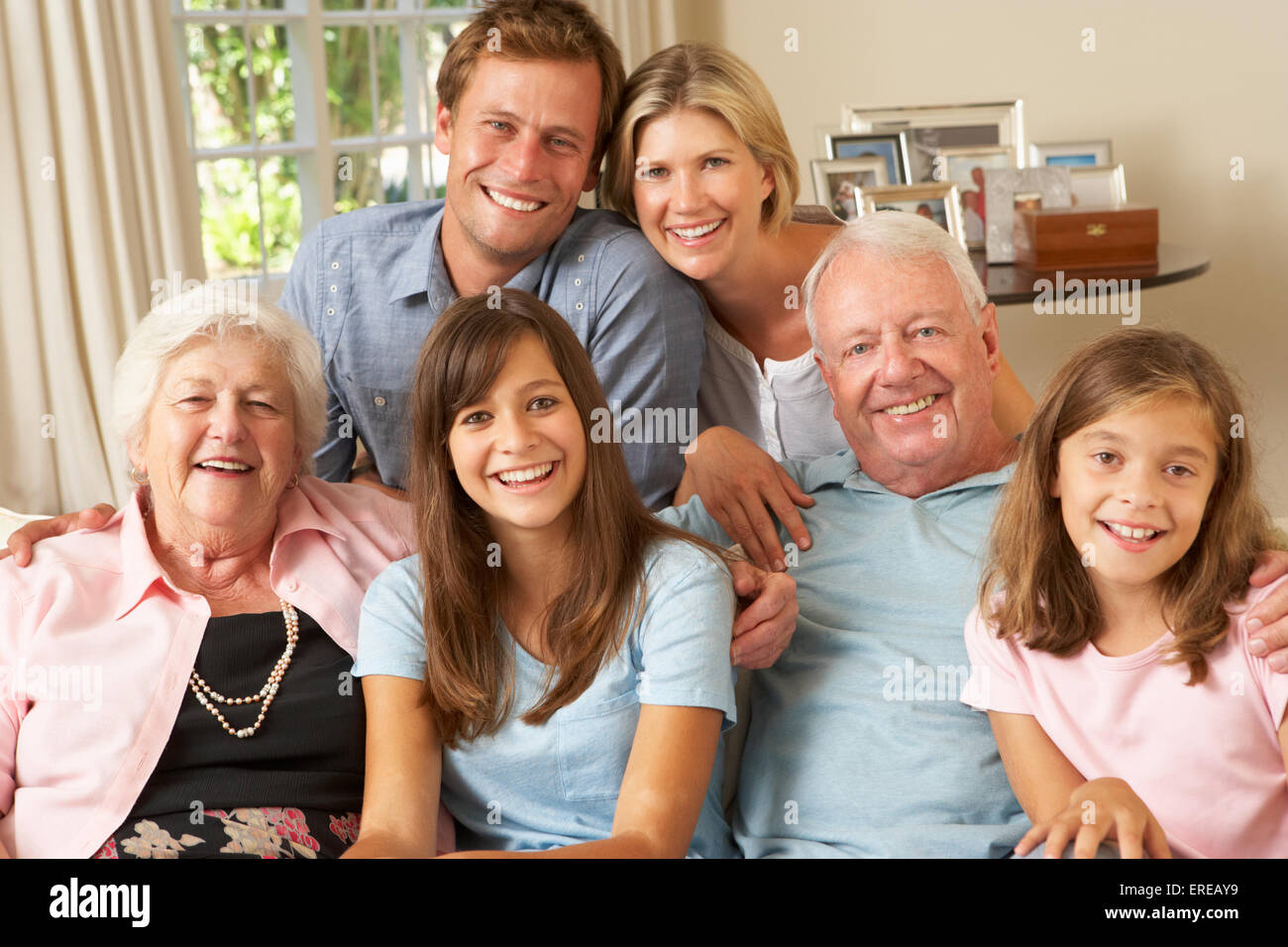 Multi Generation Family Group Sitting On Sofa Indoors Stock Photo - Alamy