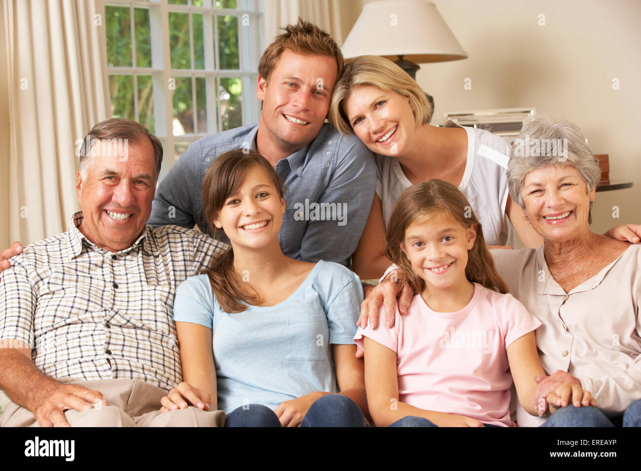 Multi Generation Family Group Sitting On Sofa Indoors Stock Photo - Alamy