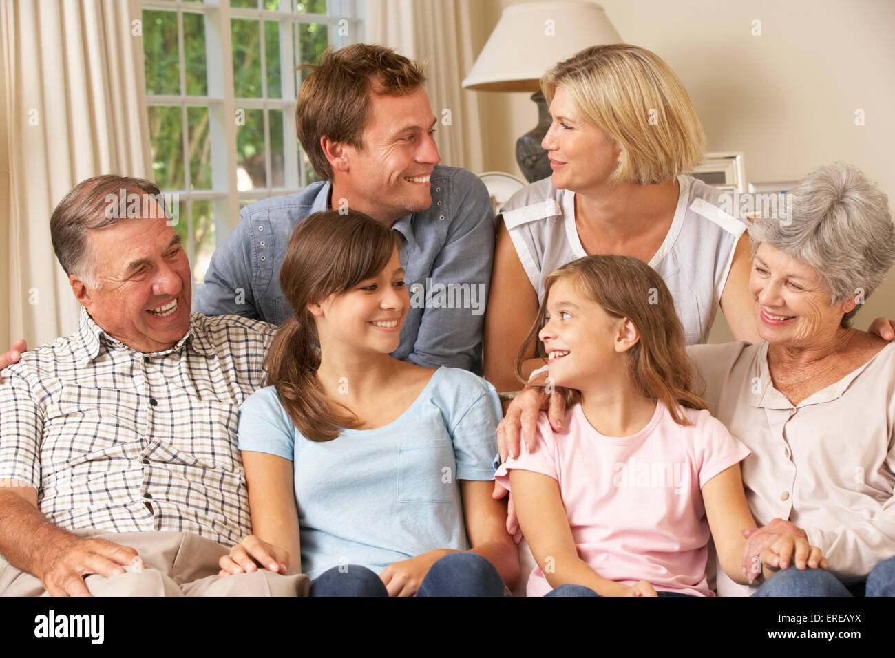 Multi Generation Family Group Sitting On Sofa Indoors Stock Photo - Alamy