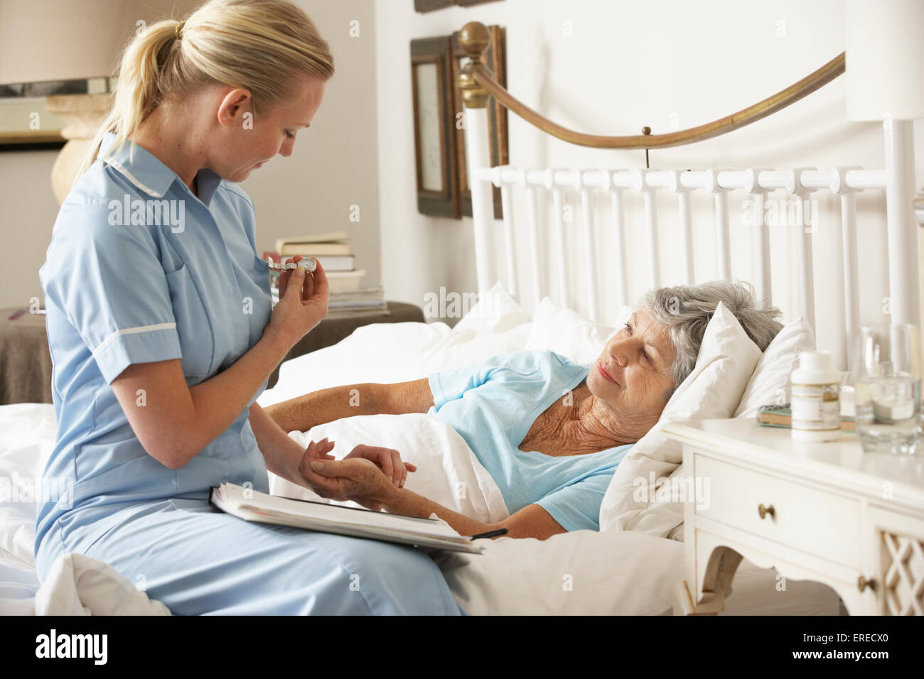 Nurse Taking Pulse Of Senior Patient Patient In Bed At Home Stock Photo ...