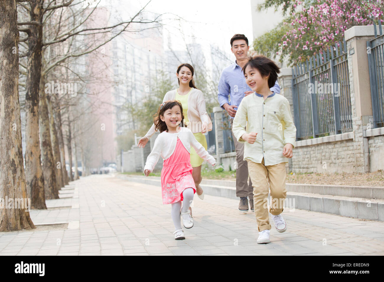 Happy young family running Stock Photo - Alamy