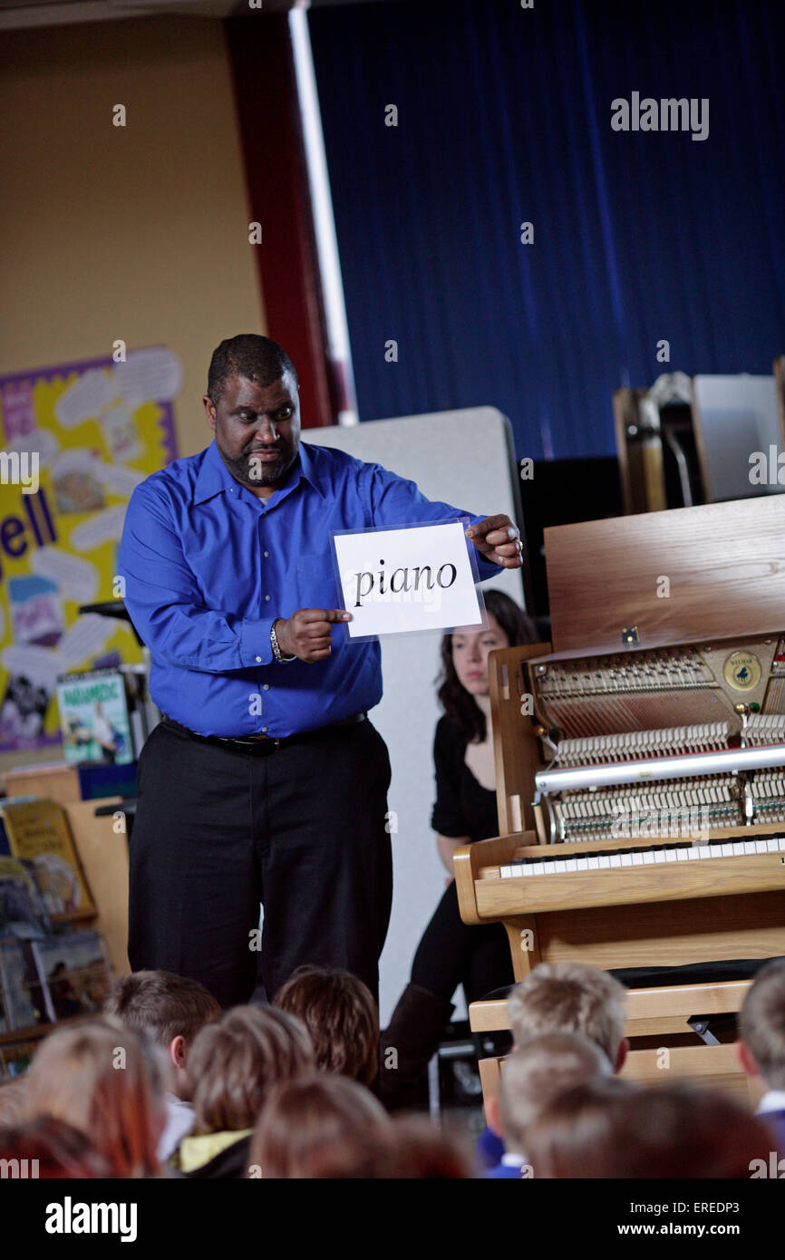 Music workshop in a school with a piano player playing to a class of ...