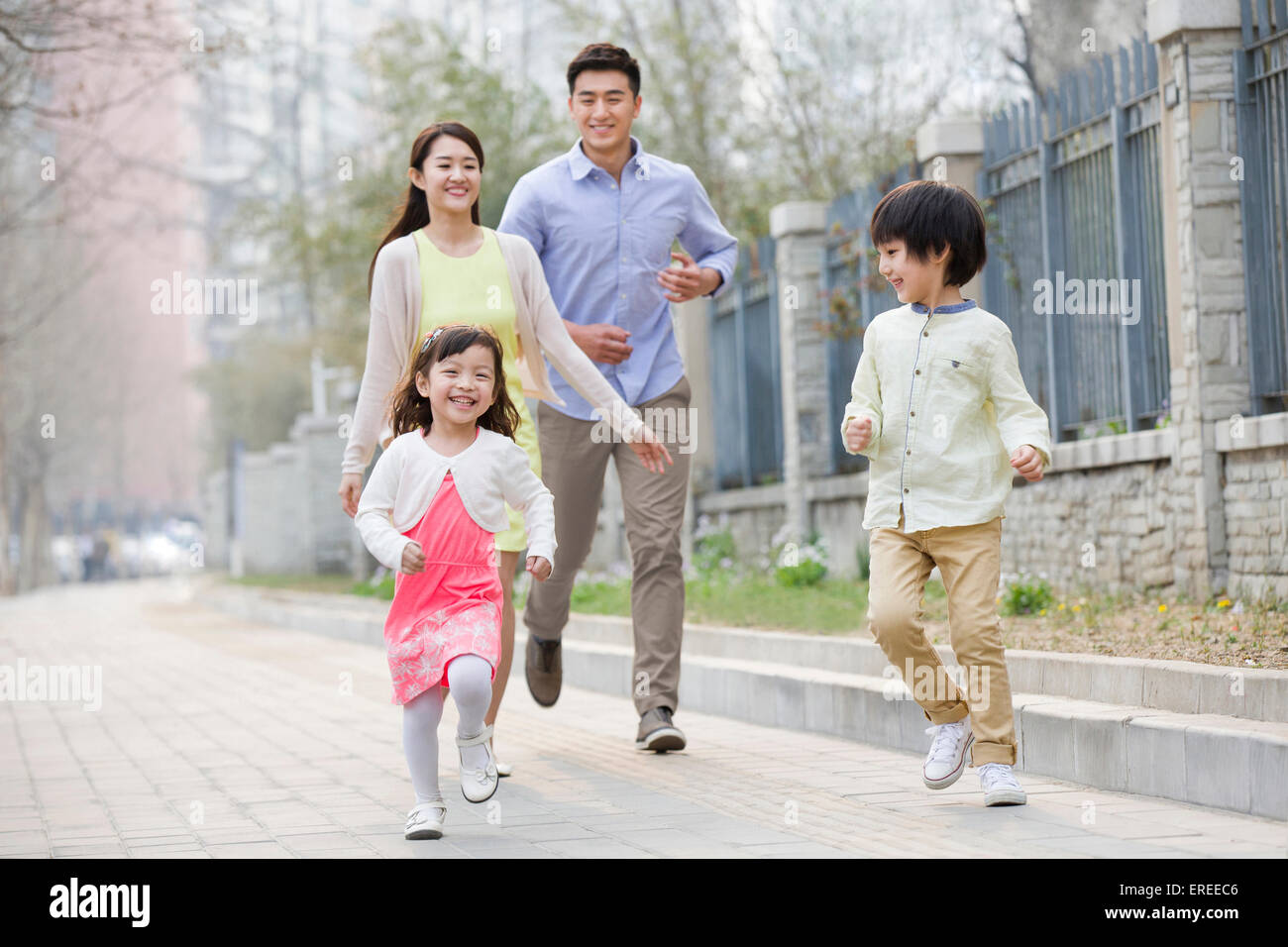 Happy young family running Stock Photo - Alamy