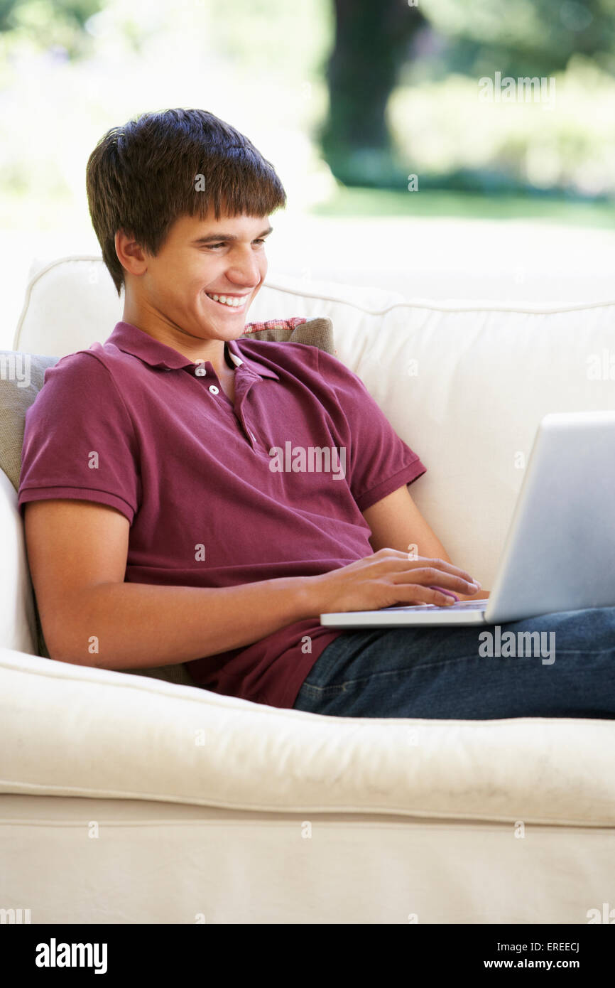 Teenage Boy Relaxing On Sofa At Home Using Laptop Stock Photo - Alamy