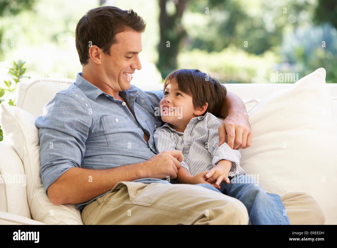 Father And Son Sitting On Sofa At Home Stock Photo - Alamy