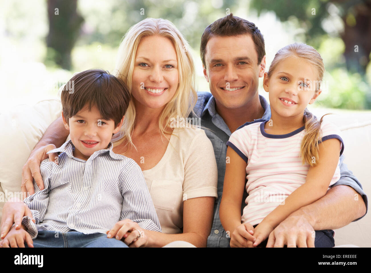 Family Sitting On Sofa At Home Stock Photo - Alamy