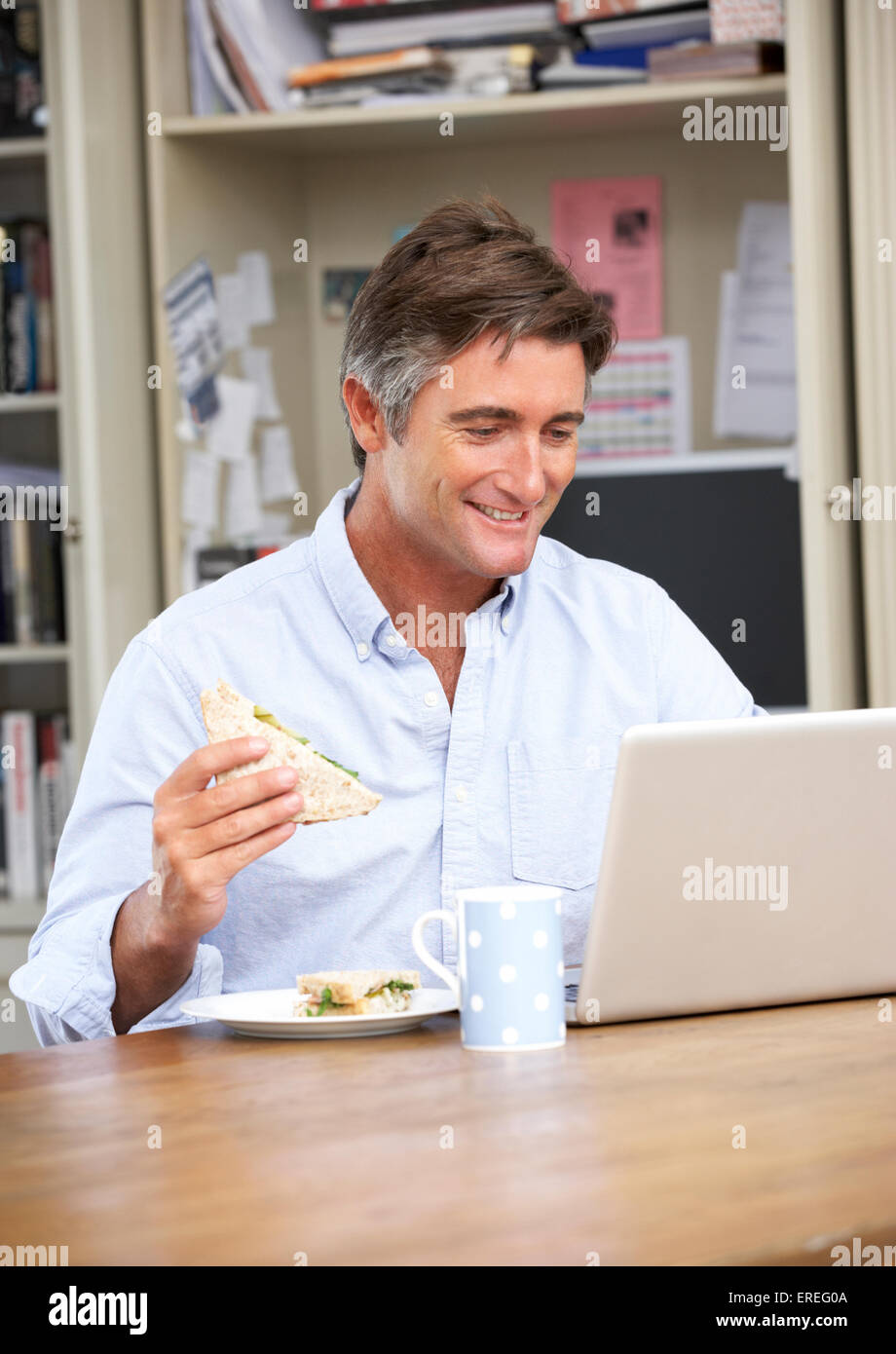 Man Having Working Lunch In Home Office Stock Photo - Alamy