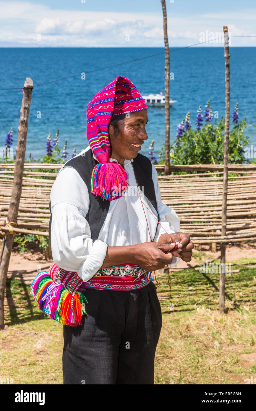Smiling Taquileño man with traditional bright knitted cap and local ...