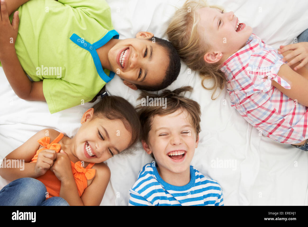 Overhead View Of Four Children Playing On Bed Together Stock Photo - Alamy