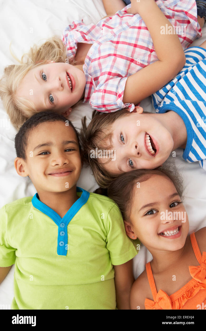 Overhead View Of Four Children Playing On Bed Together Stock Photo - Alamy