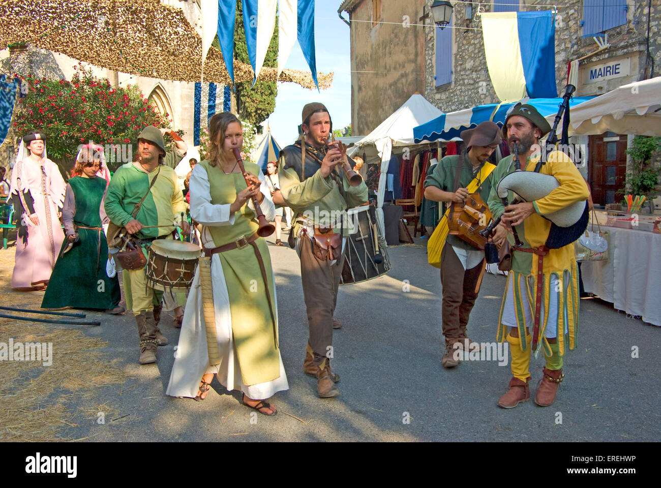 Musicians in medieval costumes, playing tabors, shawms, hurdy-gurdy and ...