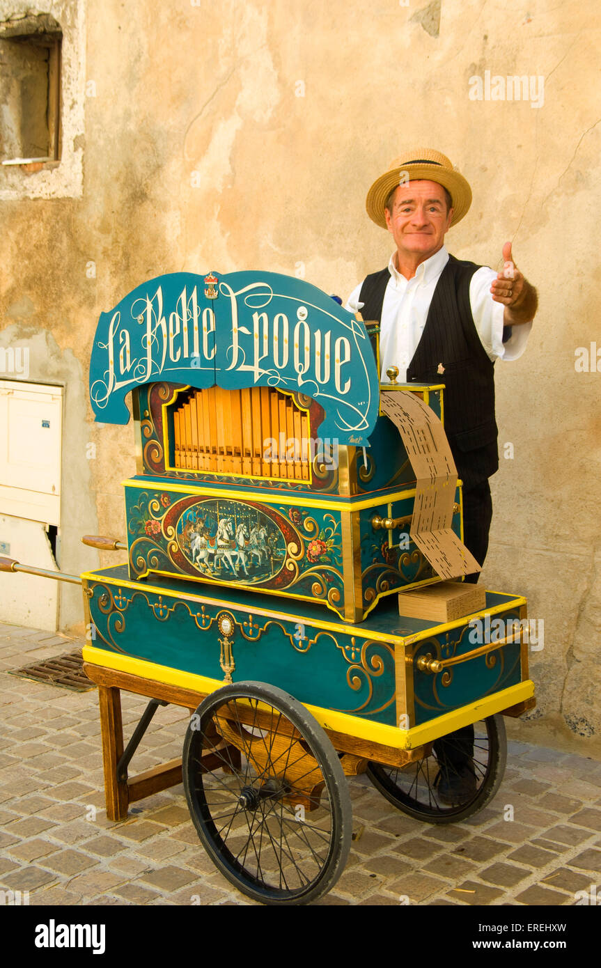 Smiling barrel organ player, in the village of Chusclan, in the ...