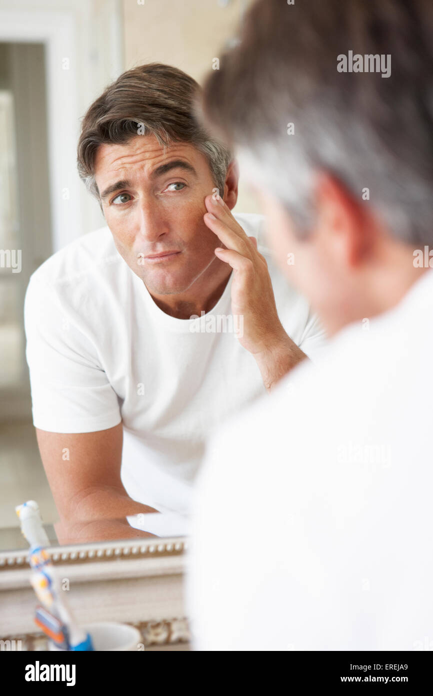 Man Looking At Reflection In Bathroom Mirror Stock Photo - Alamy