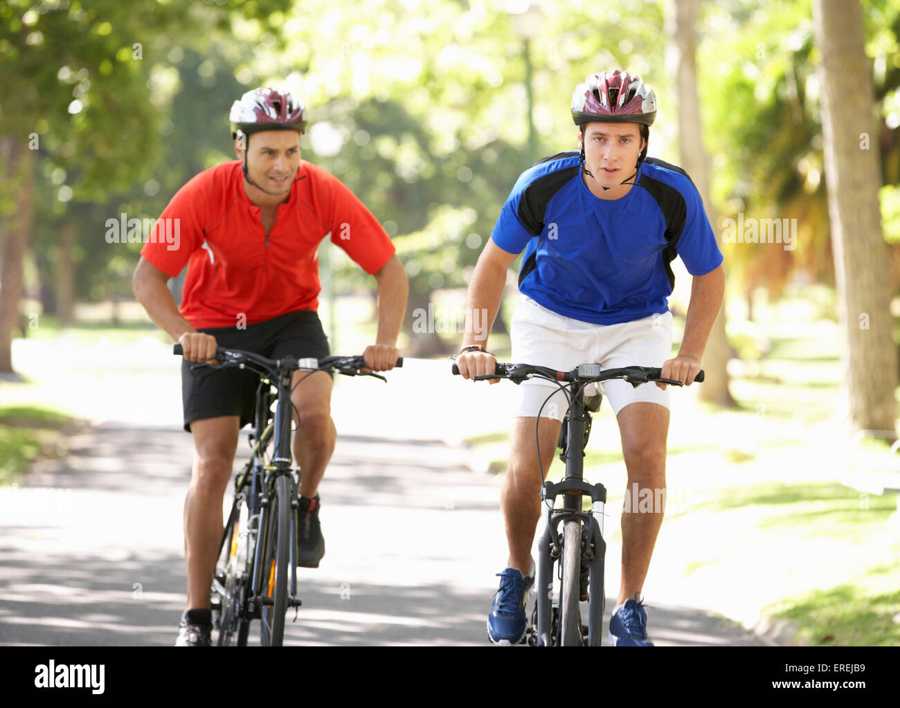 Two Men Cycling Through Park Stock Photo - Alamy