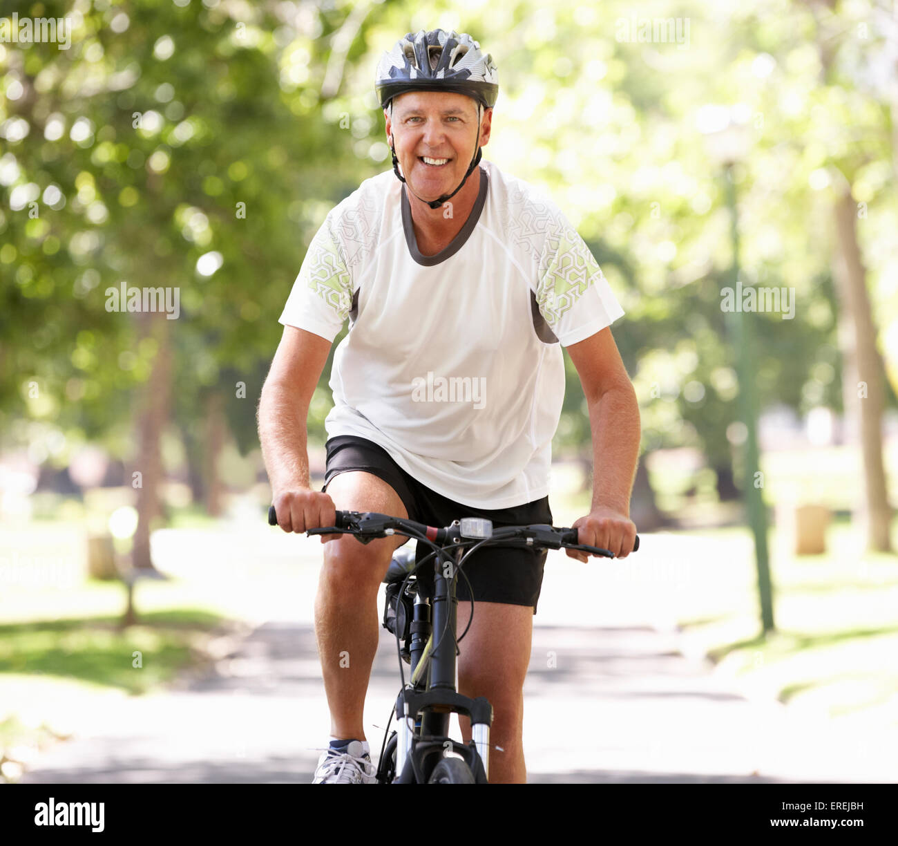 Mature Man Cycling Through Park Stock Photo - Alamy