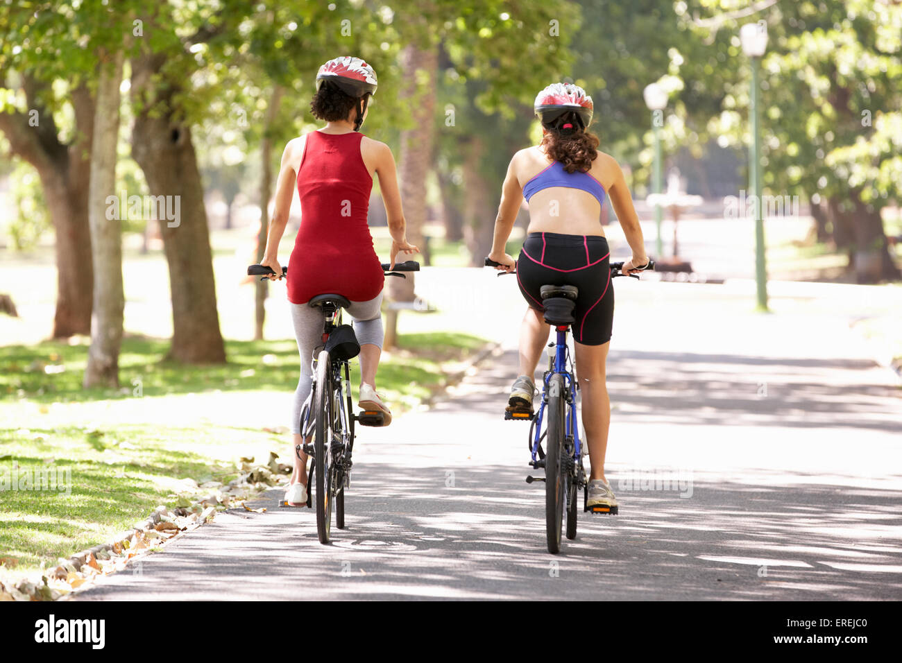 Rear View Of Two Women Cycling Through Park Stock Photo - Alamy