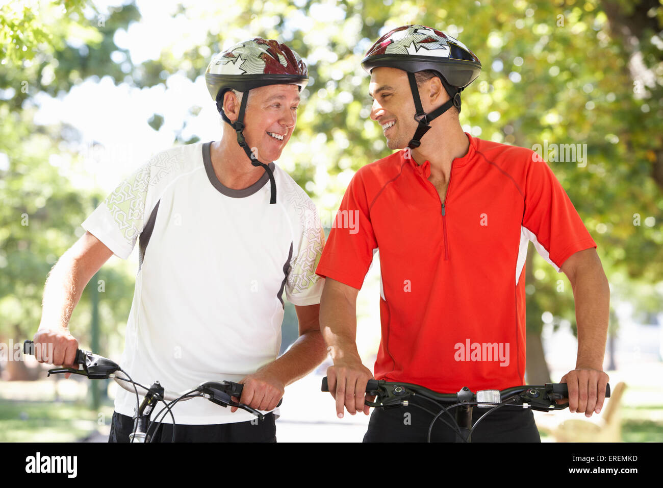 Two Men Cycling Through Park Stock Photo - Alamy
