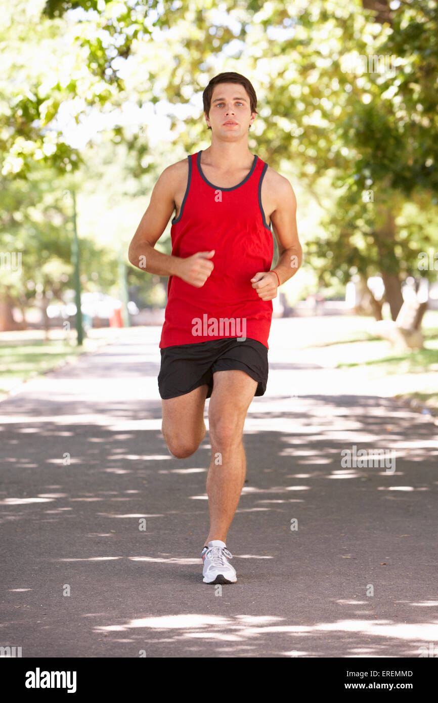 Young Man Running Through Park Stock Photo - Alamy