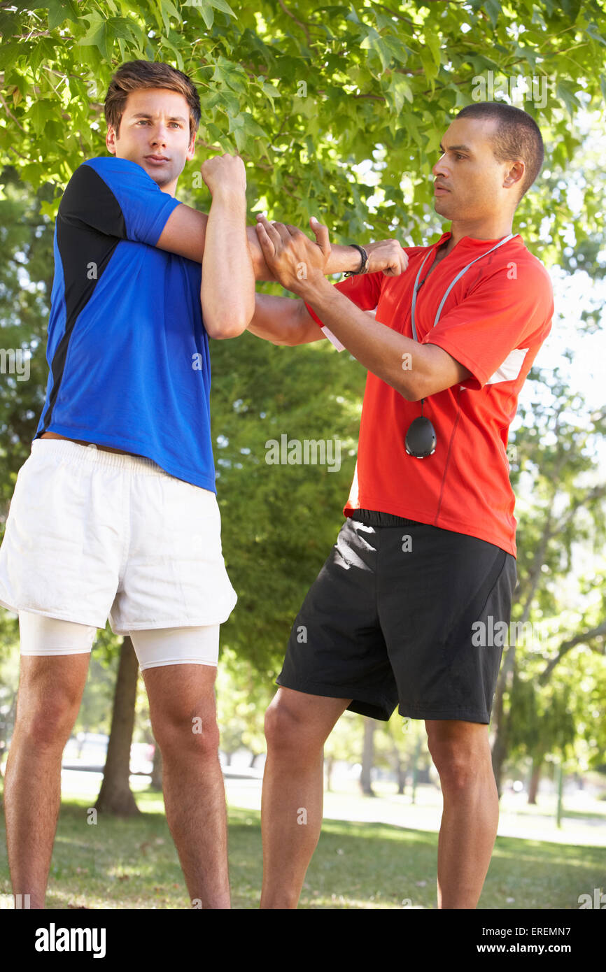 Young Man Working With Personal Trainer In Park Stock Photo - Alamy