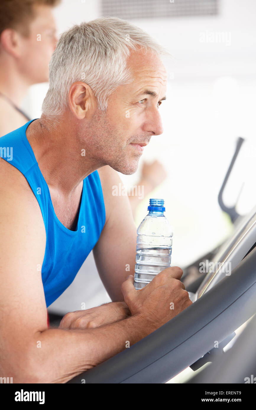 Man On Running Machine In Gym Drinking Water Stock Photo - Alamy