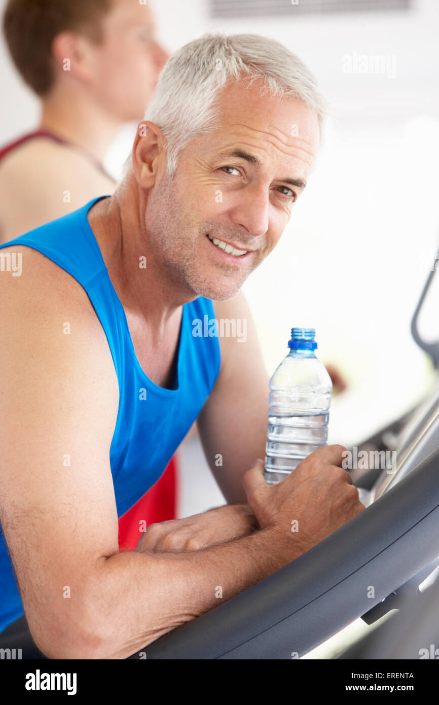 Man On Running Machine In Gym Drinking Water Stock Photo - Alamy