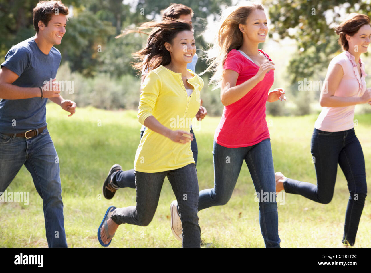 Group Of Young Friends Running Through Countryside Stock Photo - Alamy