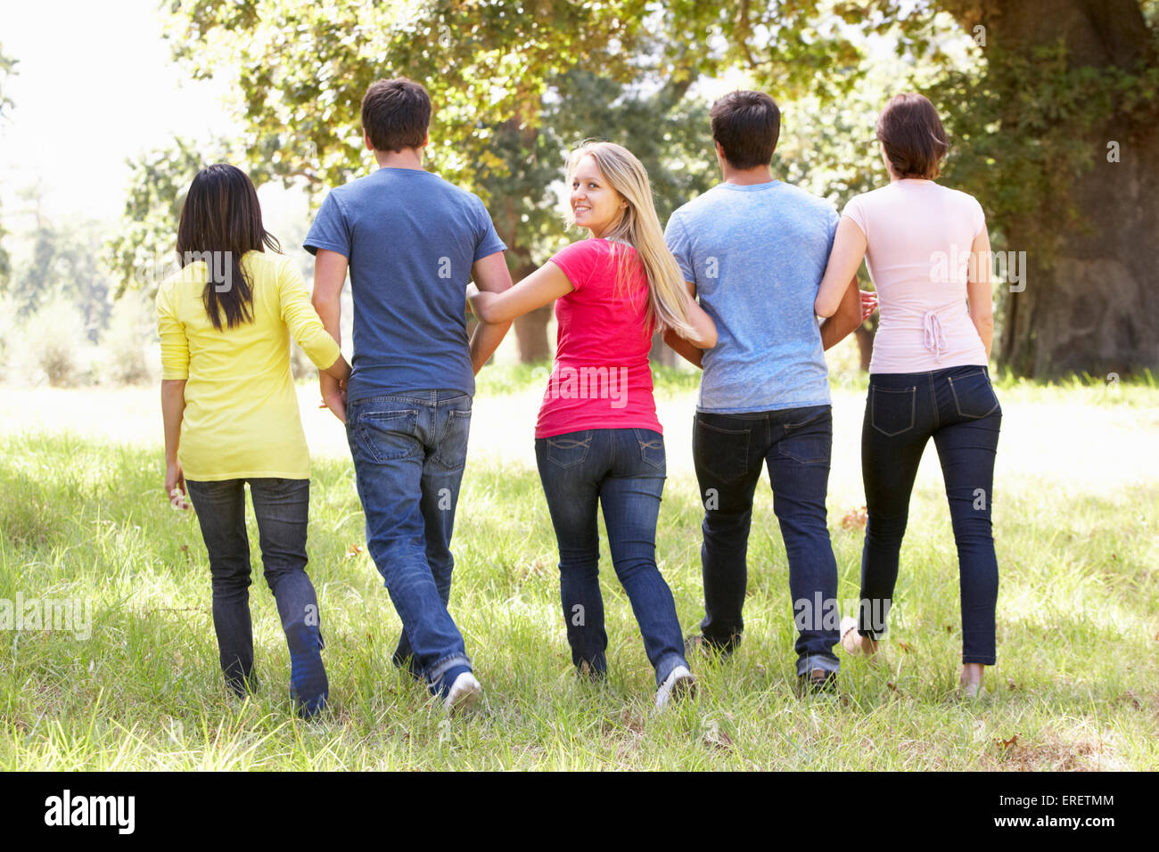 Group Of Young Friends Walking Through Countryside Stock Photo - Alamy