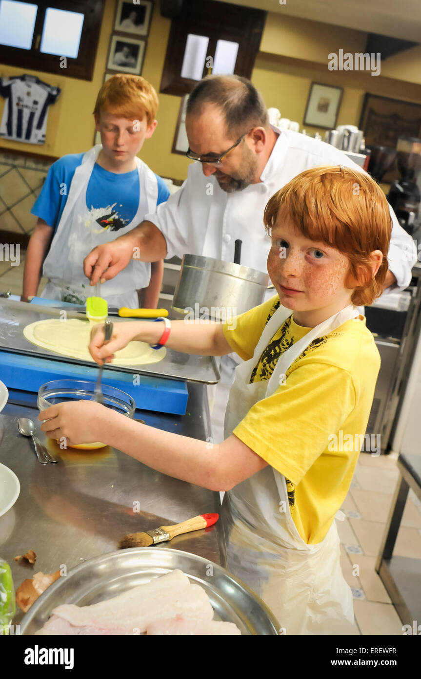Boys having a cooking lesson in a traditional members only Basque ...