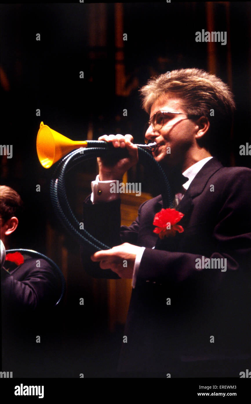 Young man playing a 'natural trumpet' composed of a mouthpiece, a ...