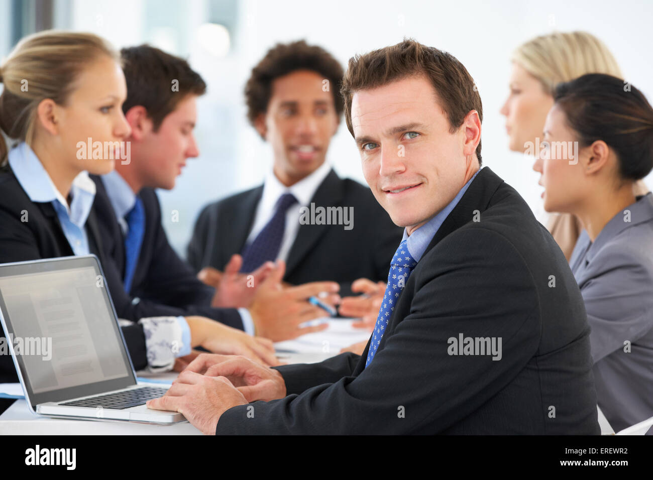 Portrait Of Male Executive With Office Meeting In Background Stock ...