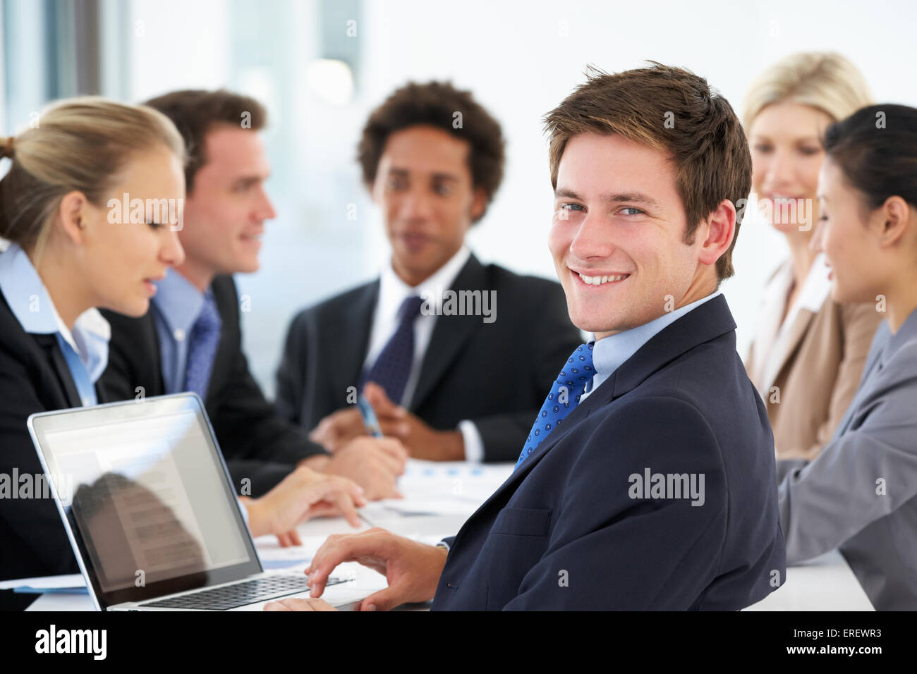 Portrait Of Male Executive With Office Meeting In Background Stock ...