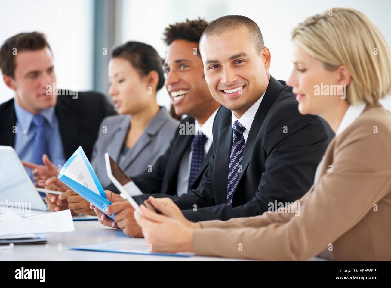 Portrait Of Male Executive Attending Office Meeting With Colleagues ...